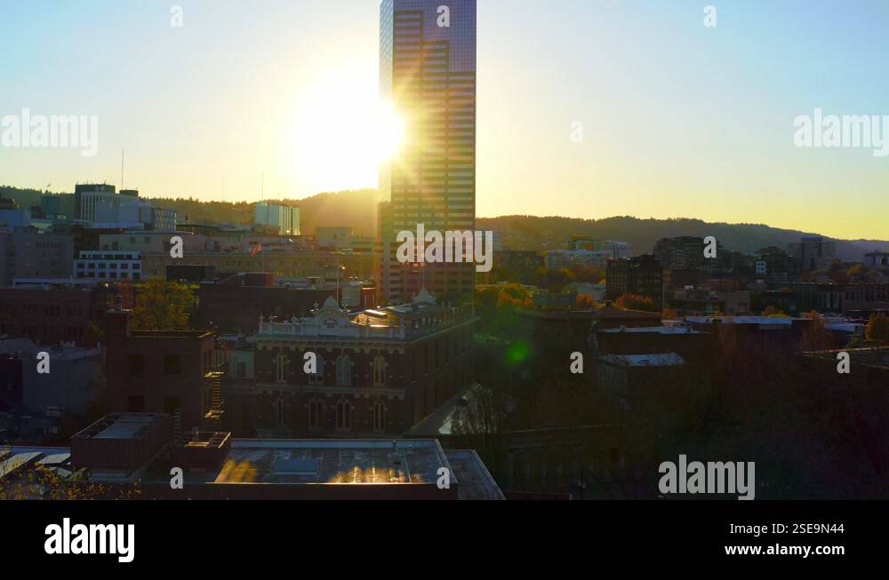 Aerial reveal of the sun behind tall skyscraper building in Portland ...