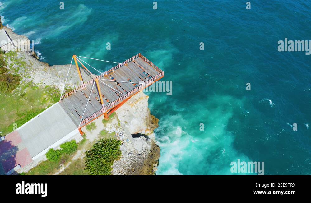 A beautiful bridge over a rocky cliff in the blue ocean Stock Video ...