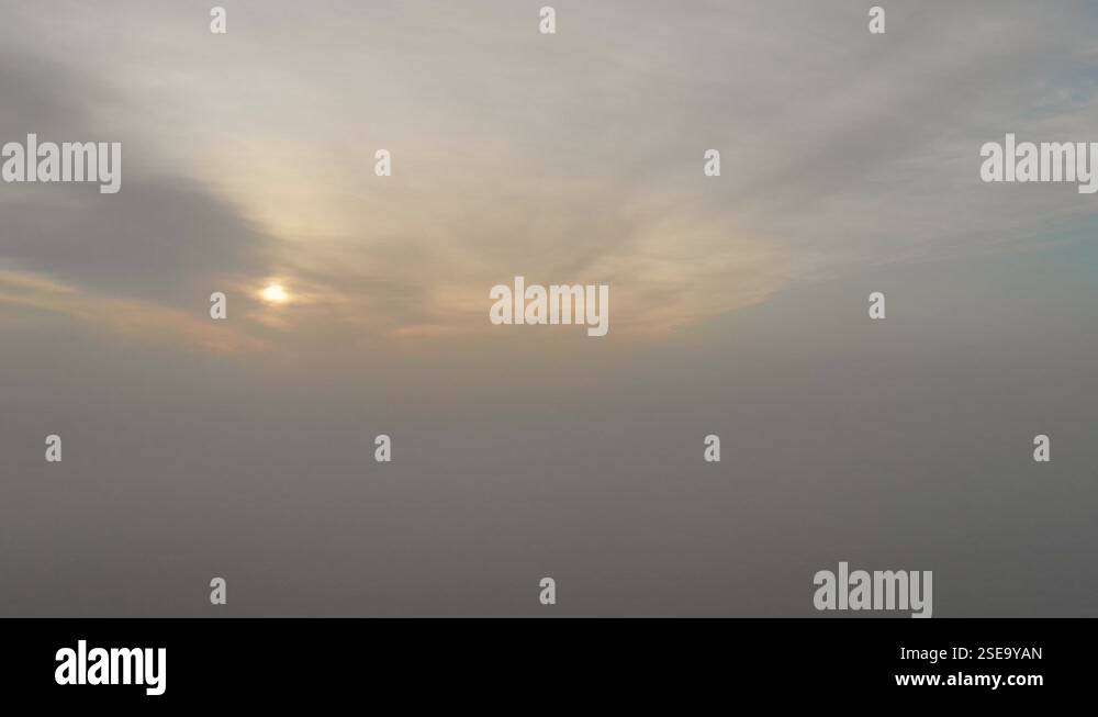 Sun rising in the cloudy sky cover by mist - aerial revealing shot ...