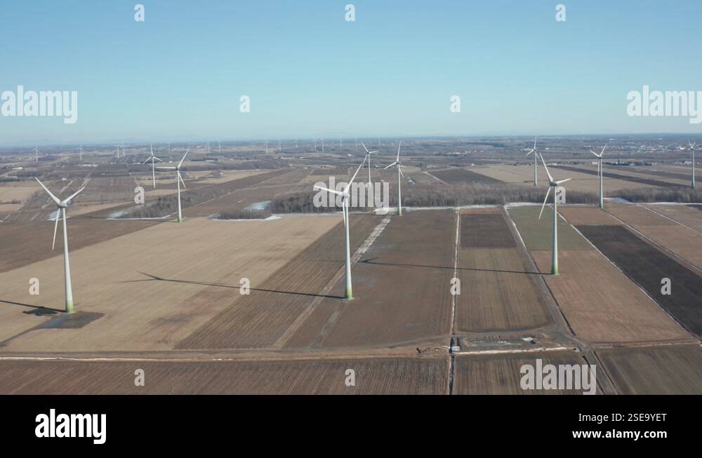 drone going around a wind farm at the begining of winter with a sunny ...