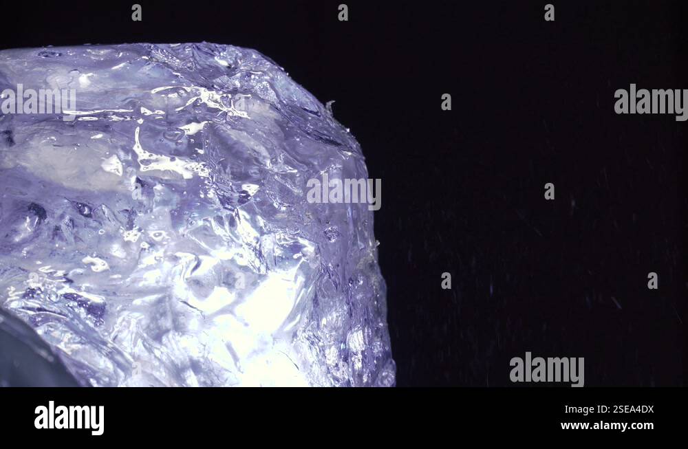 Professional artist is shaping an ice sculpture using a chisel and ...