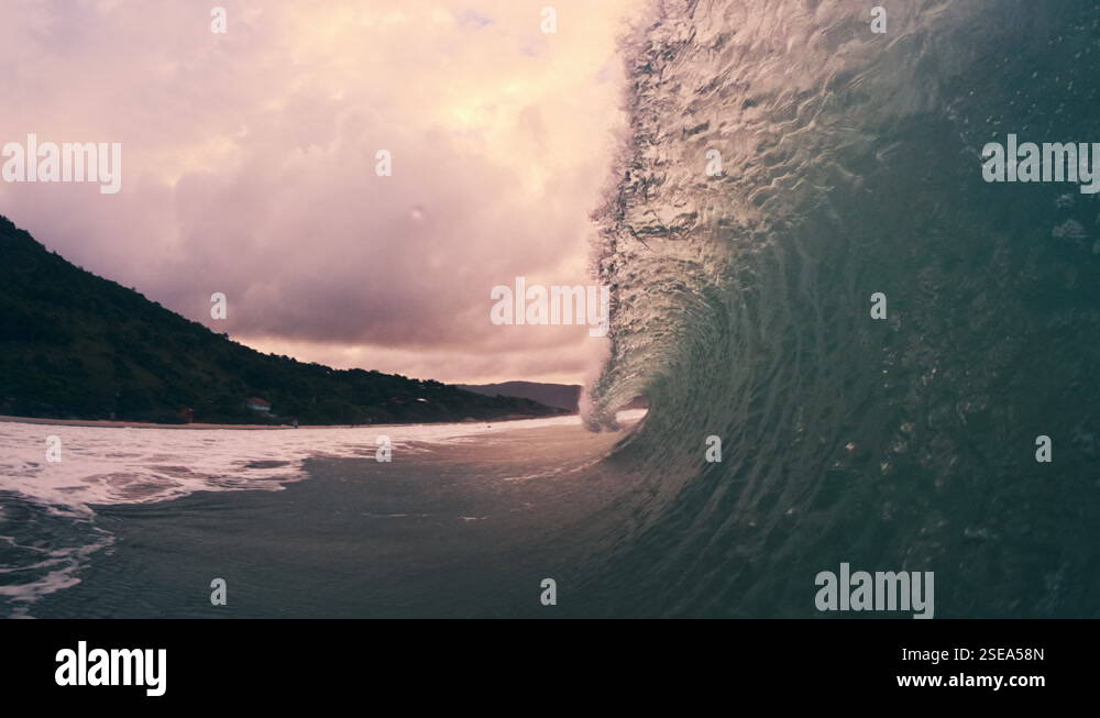 Ocean wave breaks on the shore at twilight. Wave rolls and breaks at ...