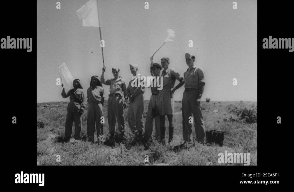 1960s: Israeli flag on pole. Soldiers on hill wave white flags. Dead ...