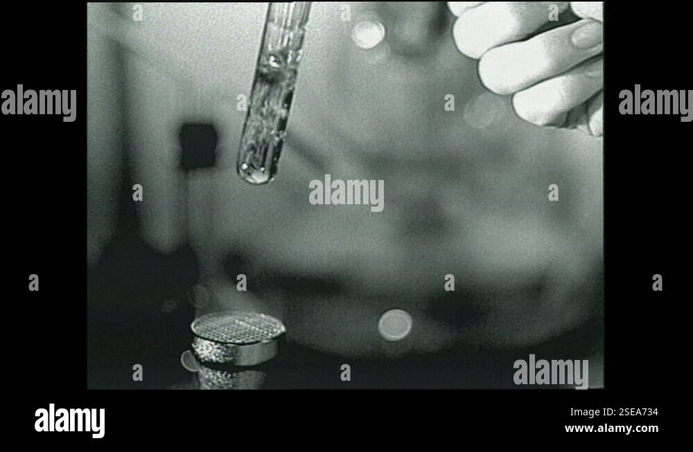1940s: Illustration of atomic model. Test tube heated over flame ...