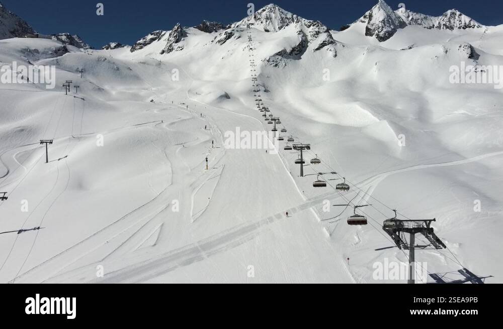 People skiing and snowboarding a slope in Austrian Alps in Stubai ski ...