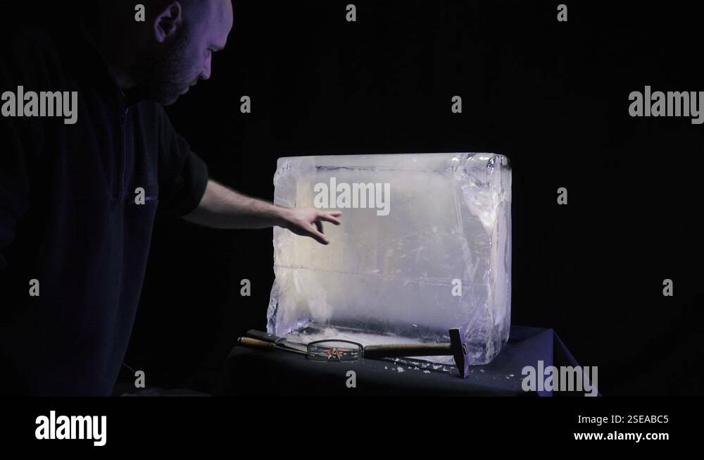Man is pointing at the spots on an ice block before making ice ...