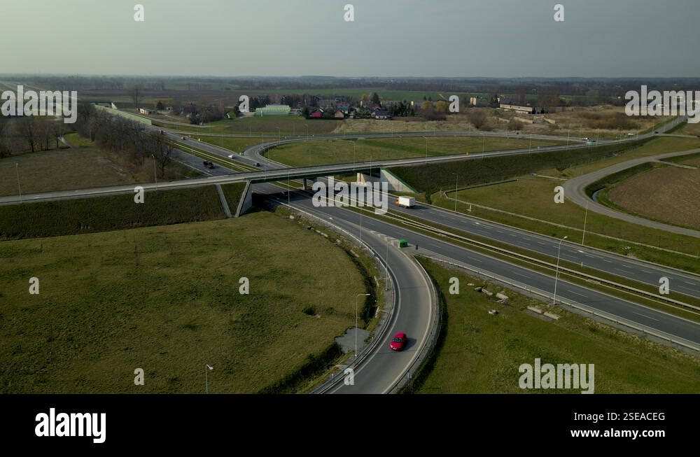 Aerial view of car traffic on highway exit ramp with bridge in rural ...