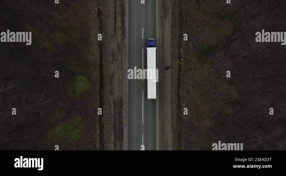 One Semi Truck with white trailer and cab driving, traveling alone on ...