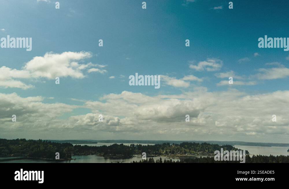 Smooth idyllic clouds swirl and boil across land and water, aerial ...