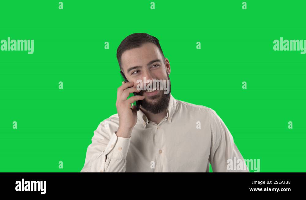 Happy business man answer and talk on the cell phone. Portrait on green ...