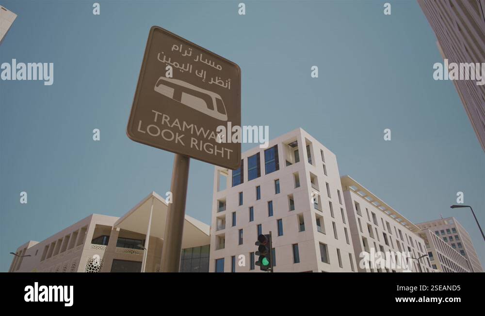 Doha Qatar - Camera tracking next to tram sign and modern arhitecture ...