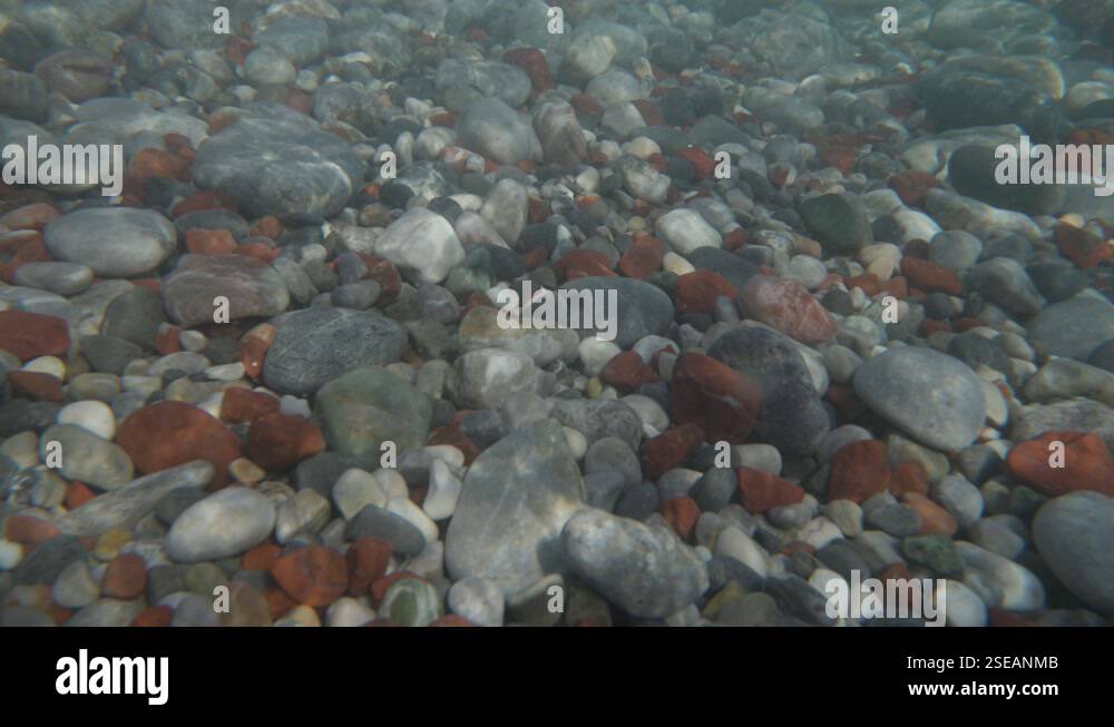 Camera is immersed in the water after the arrival of the sea wave. Slow ...