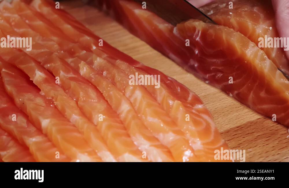Chef slicing raw salmon fish for sandwiches. Closeup cuting fresh ...