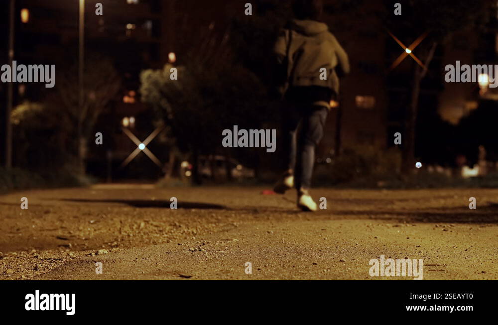danger, fear - young man in the city at night runs to escape from his ...