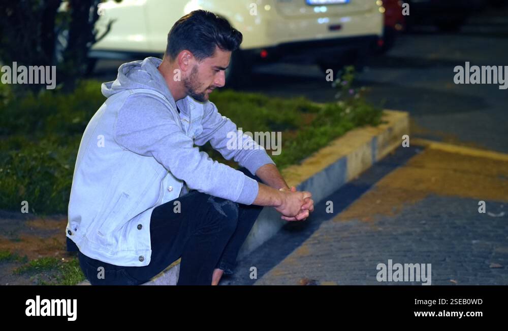 depression, solitude - sad young man sitting on the sidewalk alone thinking Stock Video Footage ...