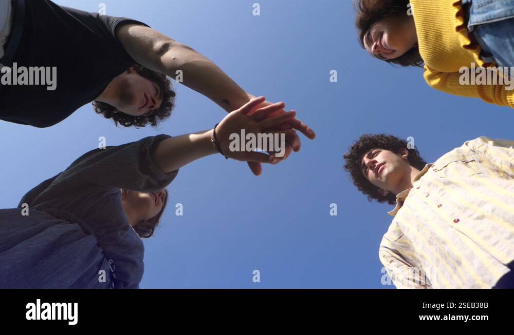 bottom-up shot of friends putting their hands on each other and ...