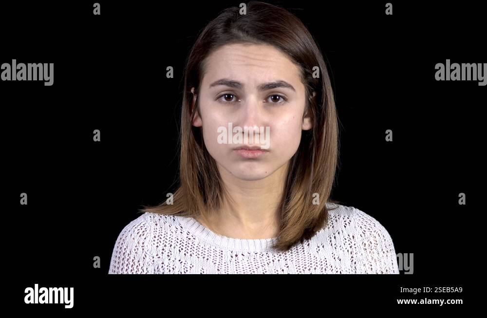 A young woman shows emotions of sadness on her face. The woman is sad ...