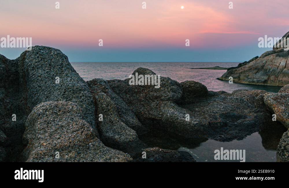 Full moon moving in colorful sky over sea and cliffs. 4K time lapse ...