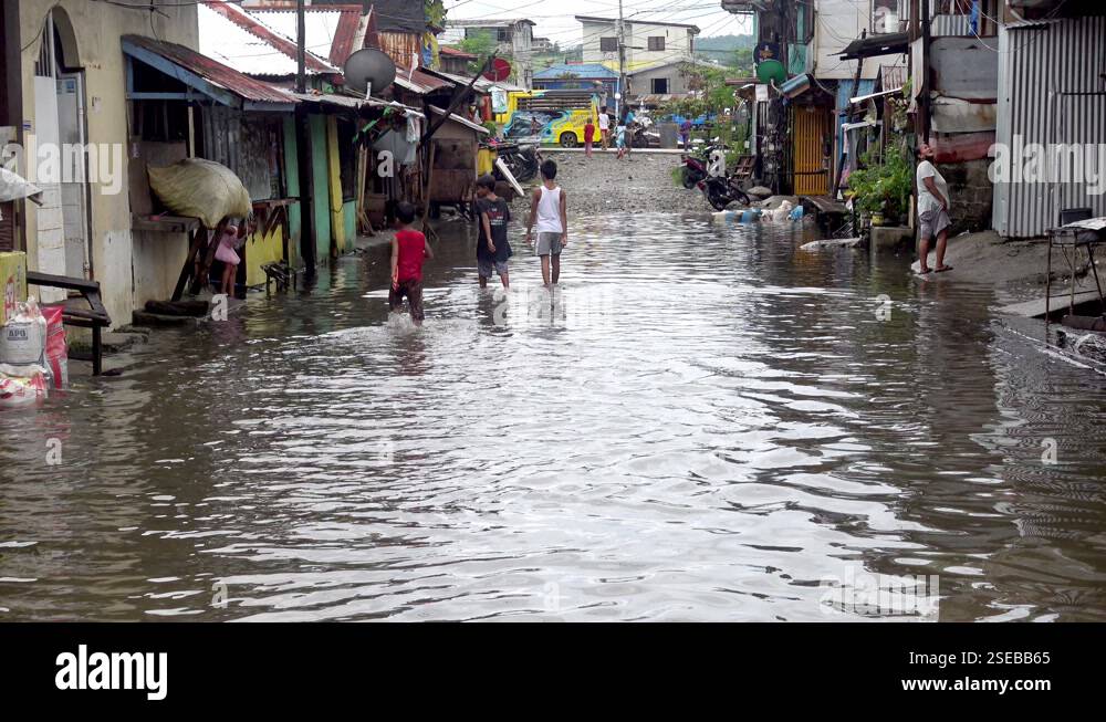 People walking through the flooded slums of Surigao City in the Stock ...