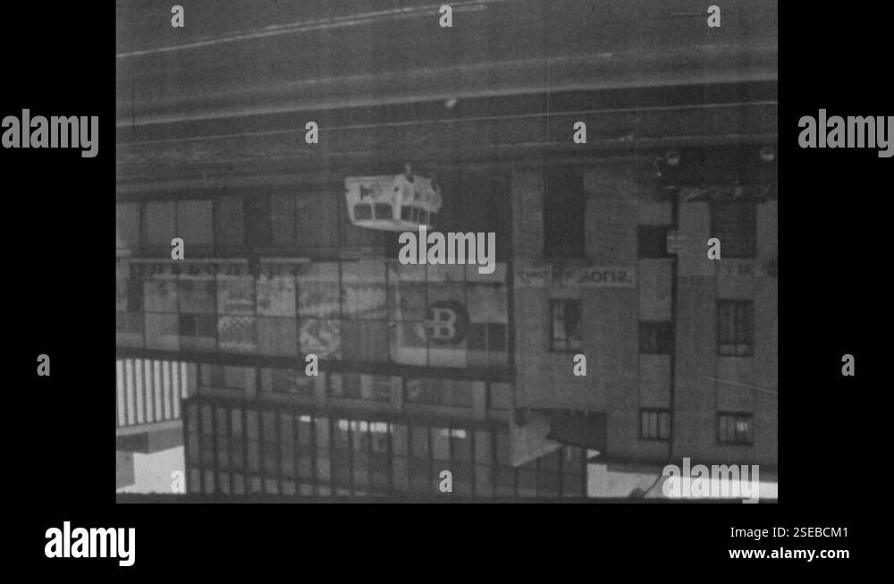 1960s: Upside down shot, bus driving onto street. Man typing at ...