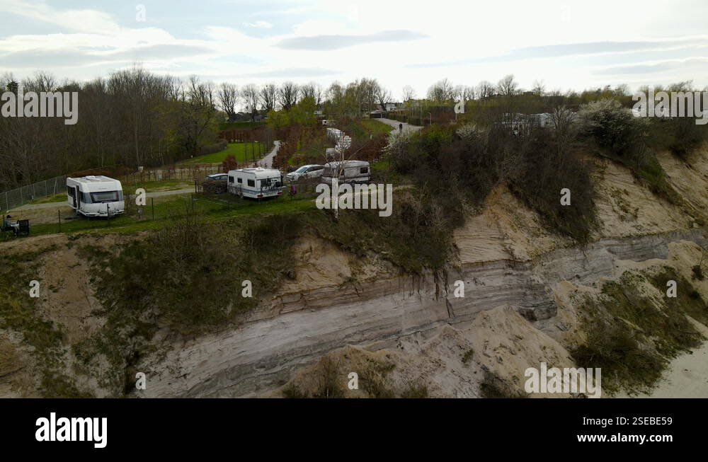 Lift up aerial reveal of the caravan and camping along the cliffs of ...