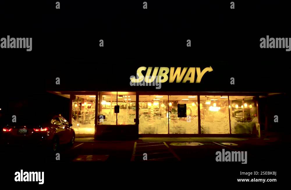 Subway at night with holiday decorations in the windows with ...