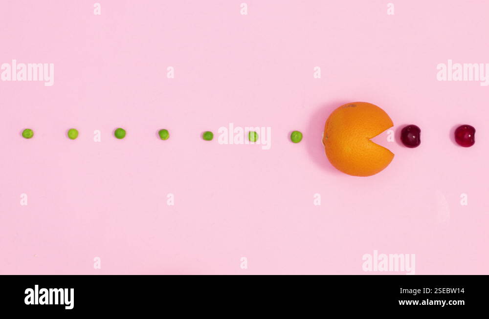 Creative Pac - man game made of fresh orange eat cherries and peas ...