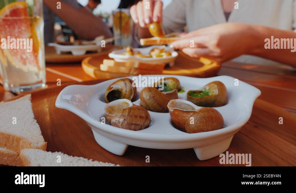 A man eats an exquisite dish of snail. Tasting snails on the farm Stock ...
