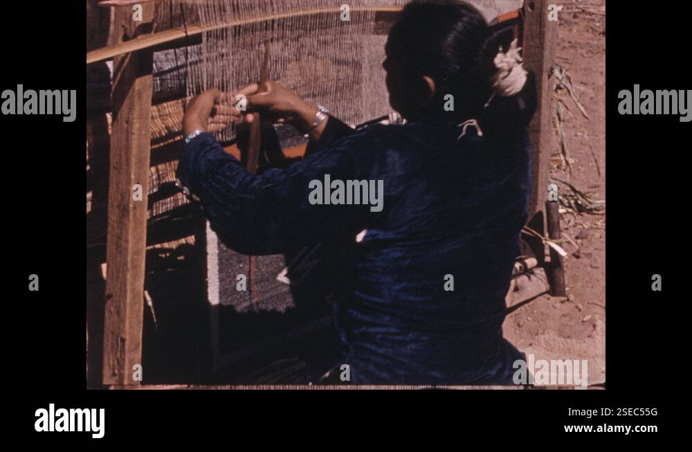 1950s: Woman weaves wool across wood frame creating pattern in material ...