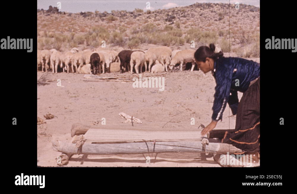 1950s: Navajo woman kneels and inserts sticks into loom on the ground ...