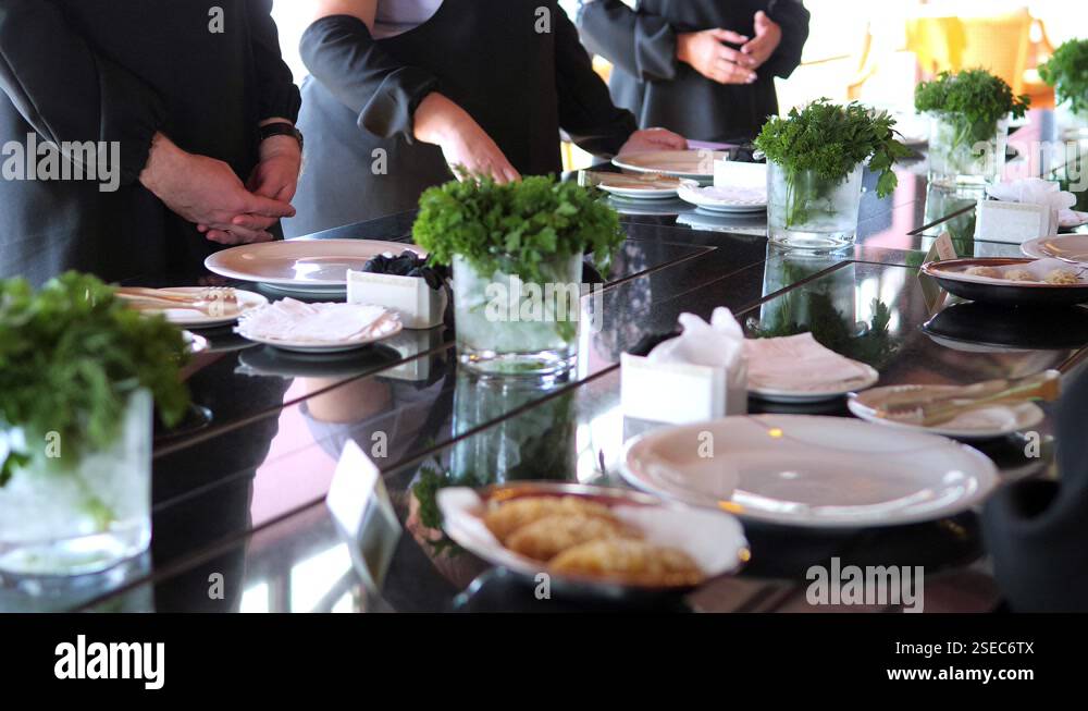 A lot of cooks stand near ready-made dishes, a lot of greens in the ice ...
