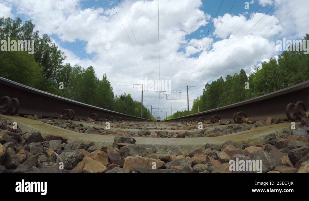 The electric train rides on the rails and approaches the camera on the ...