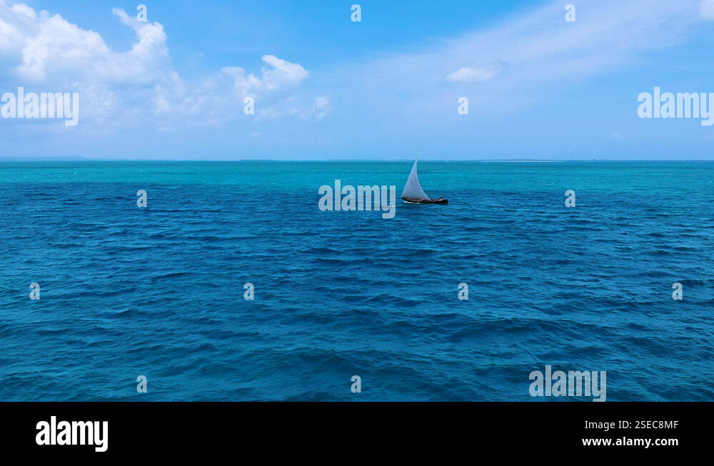 Aerial forward of traditional dhow boat sailing on pristine sea ...