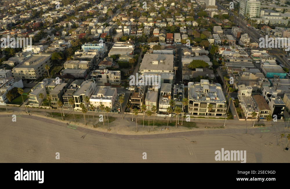 Aerial Tilt Down Shot Of Residential Structures In City By Beach During ...