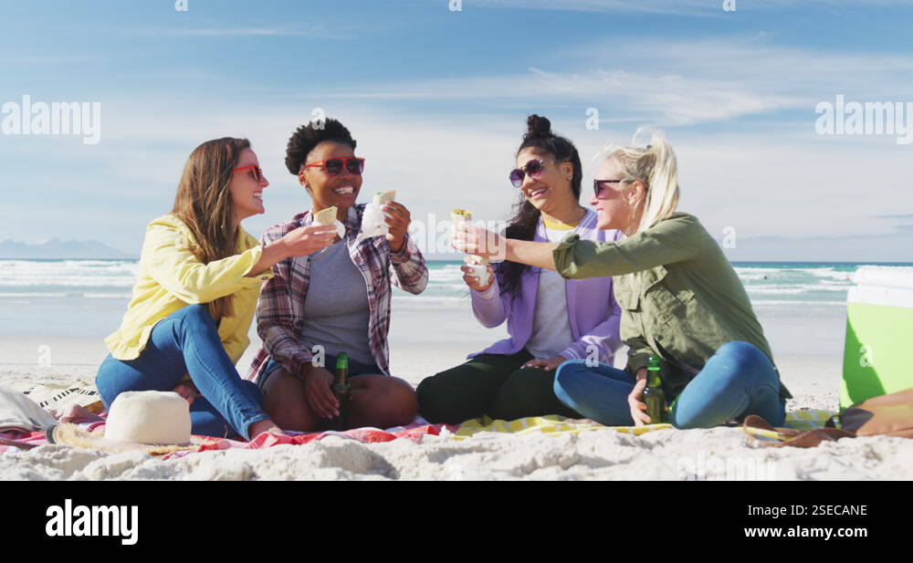 Happy group of diverse female friends having fun, having picnic at the ...