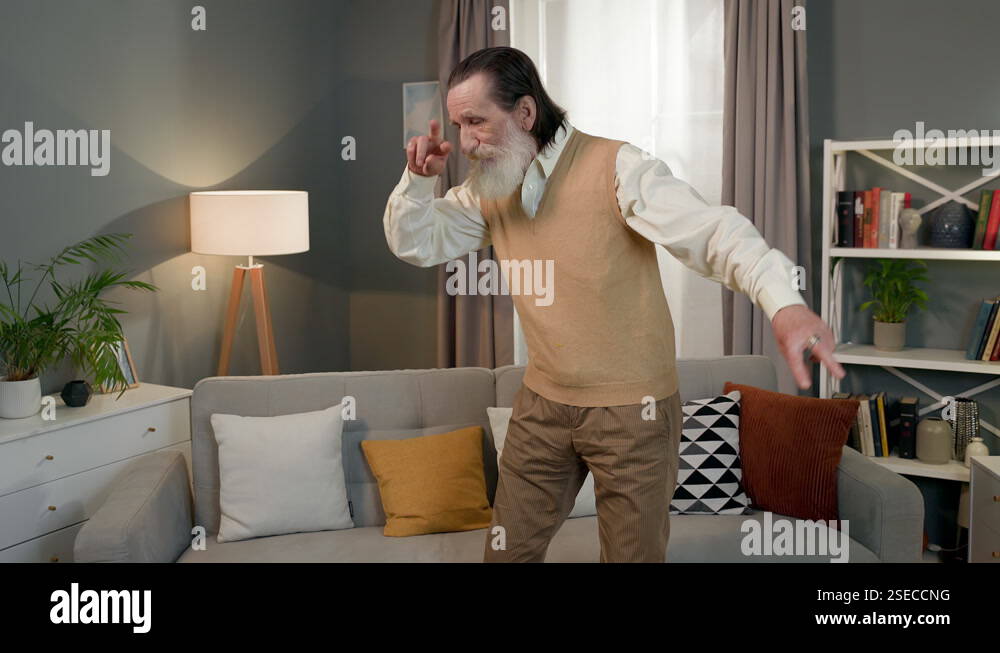 Old Man Dancing In The Apartment. He Makes Rhythmic Movements Near Sofa ...