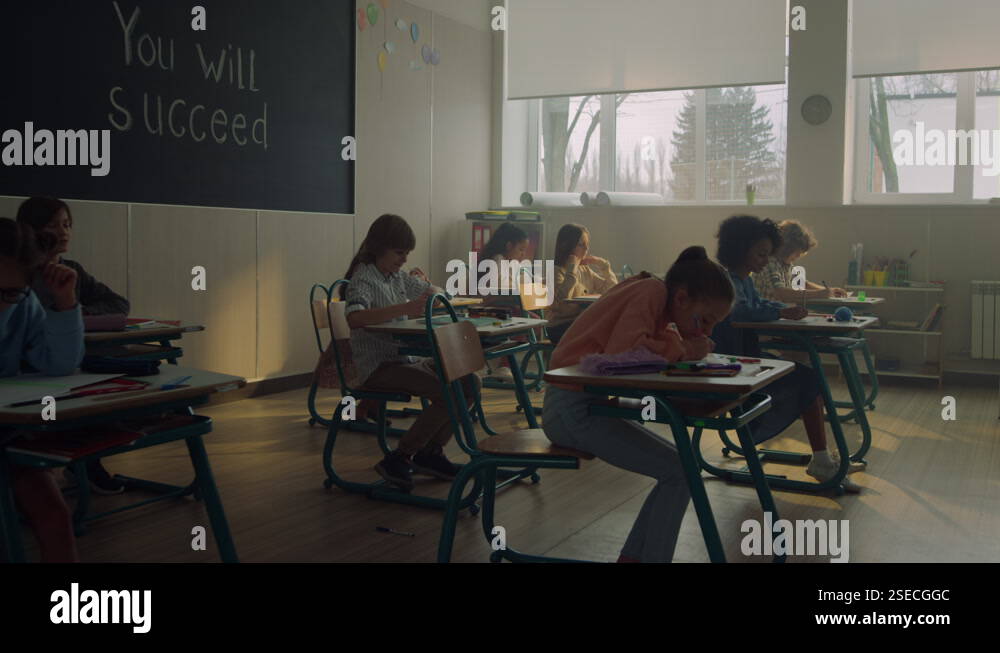 Schoolchildren studying in school class. Students doing class work in ...
