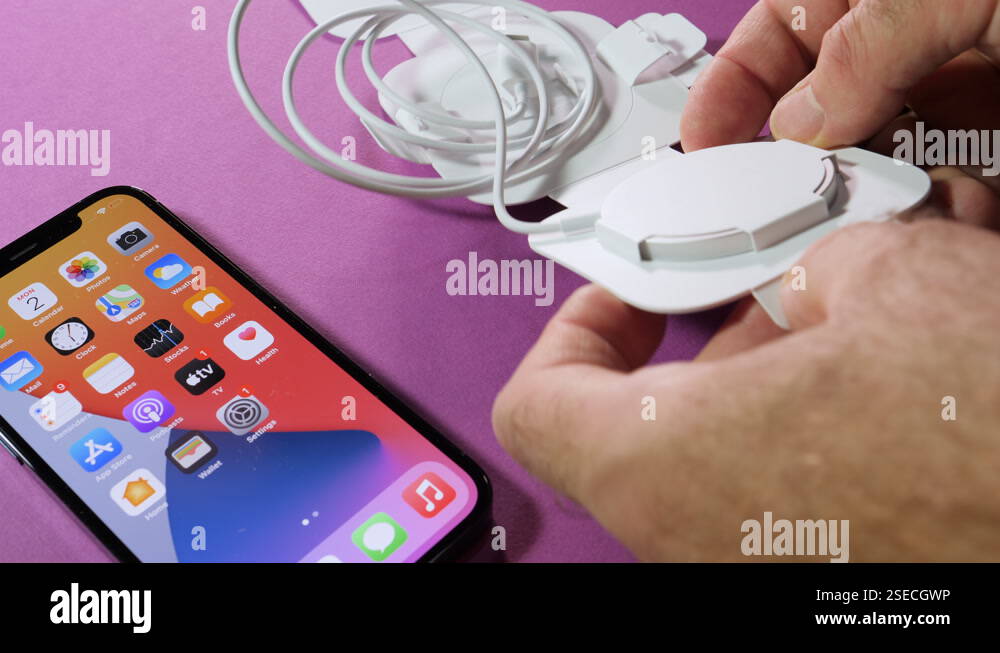 Man hand unboxing new MagSafe wireless power charger for iPhone 12 Pro ...