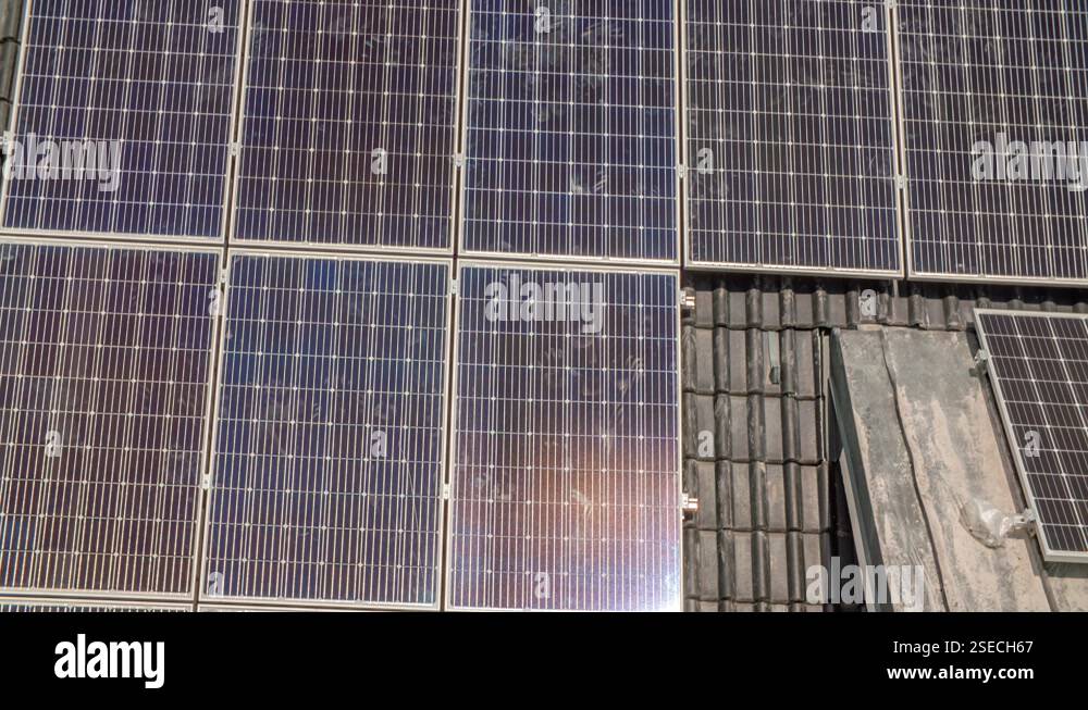 Tilt down shot showing farm of solar panels on roof of residential ...