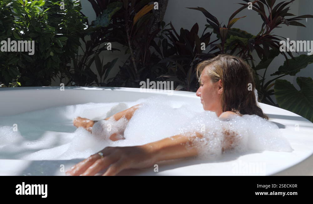 Healthy female taking a bath in slow-motion in luxury resort spa Stock ...