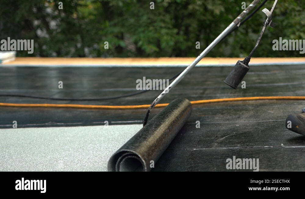 Heating Roll Of Bitumen Roofing Felt With Gas Torch Flame. close up ...