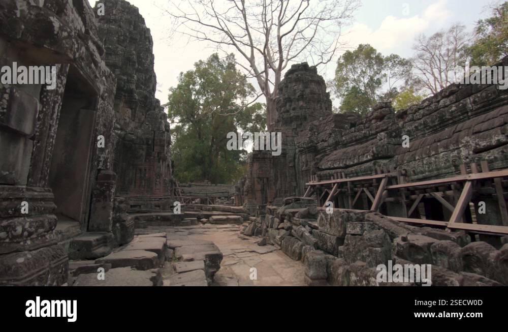 Walking through a richely decorated but broken down temple in Angkor ...