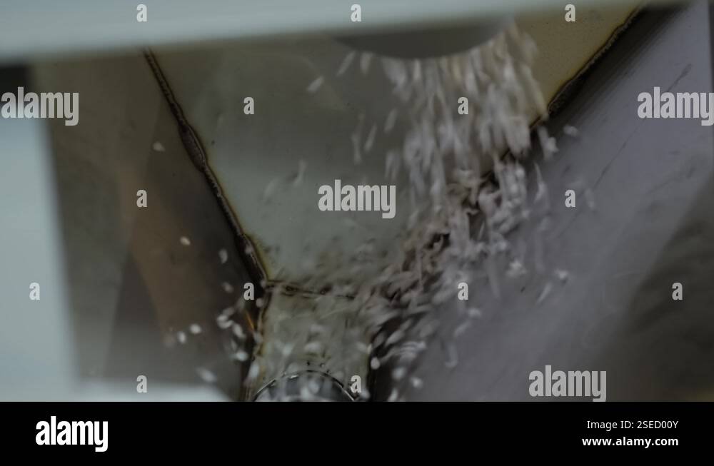 Recycled plastic granules, pellets falling in metal container: close up ...