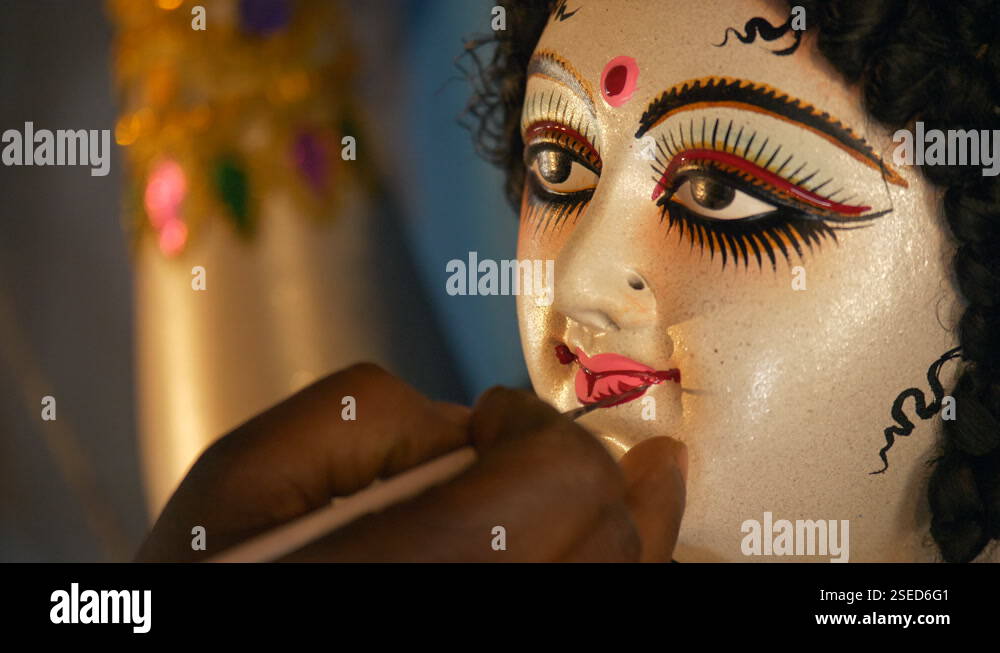 Hands of an Indian artist coloring the lips of clay sculpture of ...