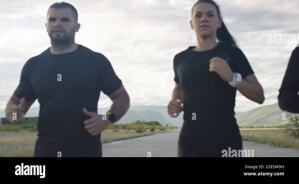 Multiethnic group of athletes running together on a panoramic road ...