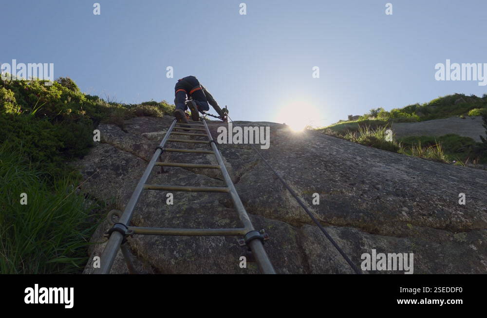 Man rock climber ascending via ferrata route on alpine terrain Stock ...