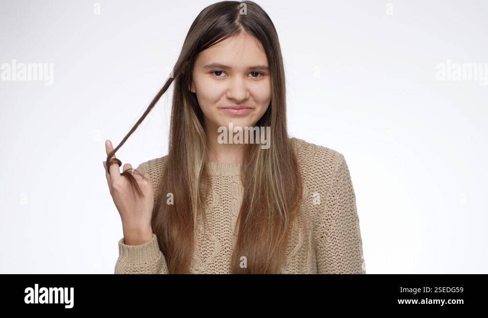 Beautiful charming girl twisting long hair on finger and smiling in ...