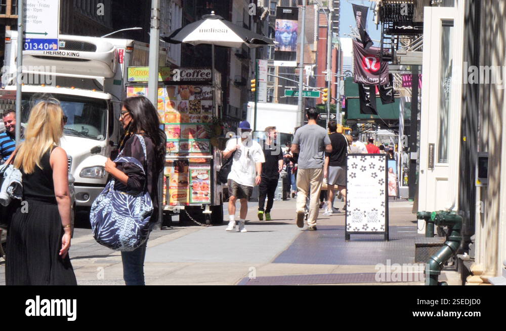 People walk along the fashion stores on Soho district of Midtown ...