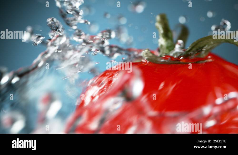 Super slow motion of rotating tomato with splashing water around Stock ...