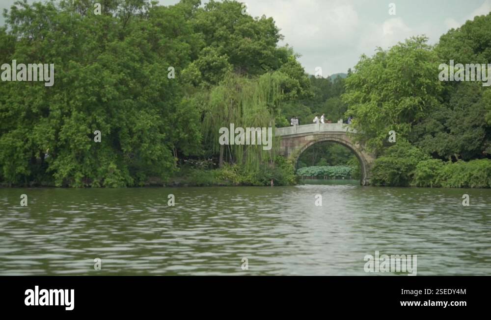 View from the West Lake in Hangzhou China with a bridge, vegetation and ...